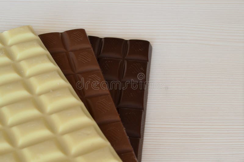 Three Bars of Chocolate Lie on a White Wooden Table Stock Image - Image ...