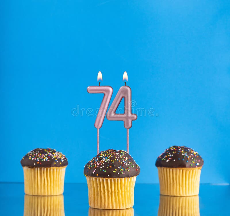 Three Birthday Cupcakes with Number 74 Candle - Blue Background Stock ...