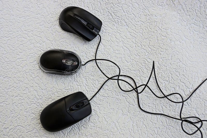 Three Black Computer Mice with a Wire on a Gray Surface Stock Image ...