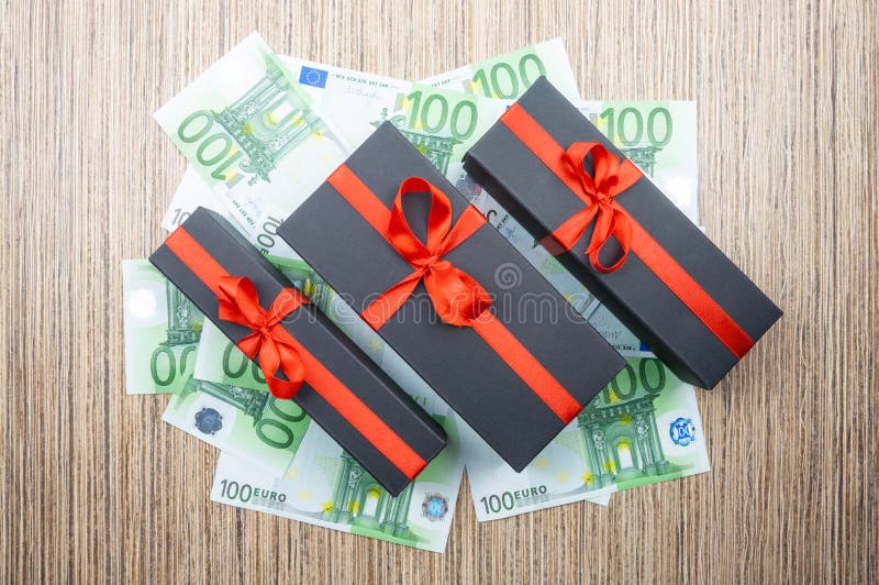 Three Black Gift Box with a Bow with Euro Banknotes on a Wooden Table ...