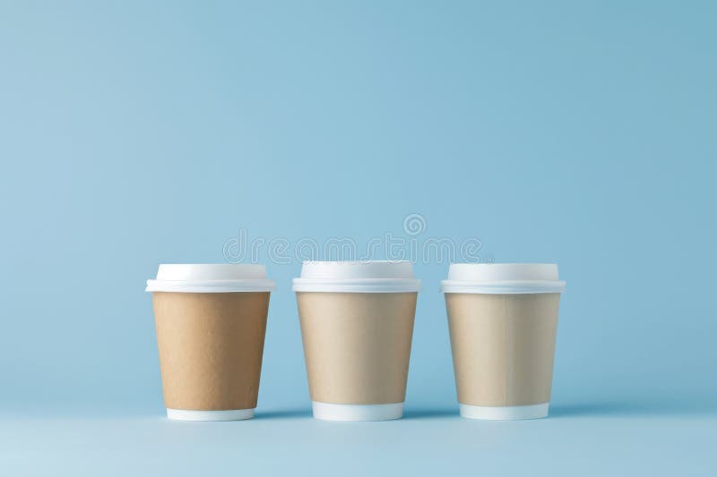 Three Blank Coffee Cups with Cardboard Sleeves, Neatly Aligned on Blue ...