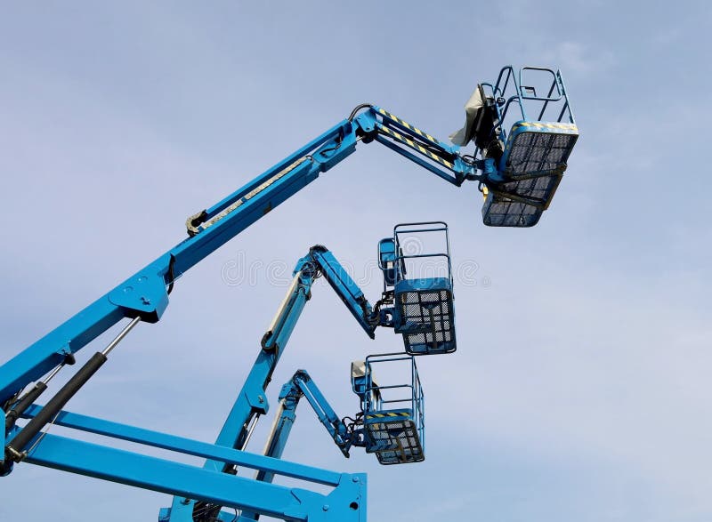 Three Blue Aerial Work Platform of Cherry Pickers, Against Blue Cloudy ...
