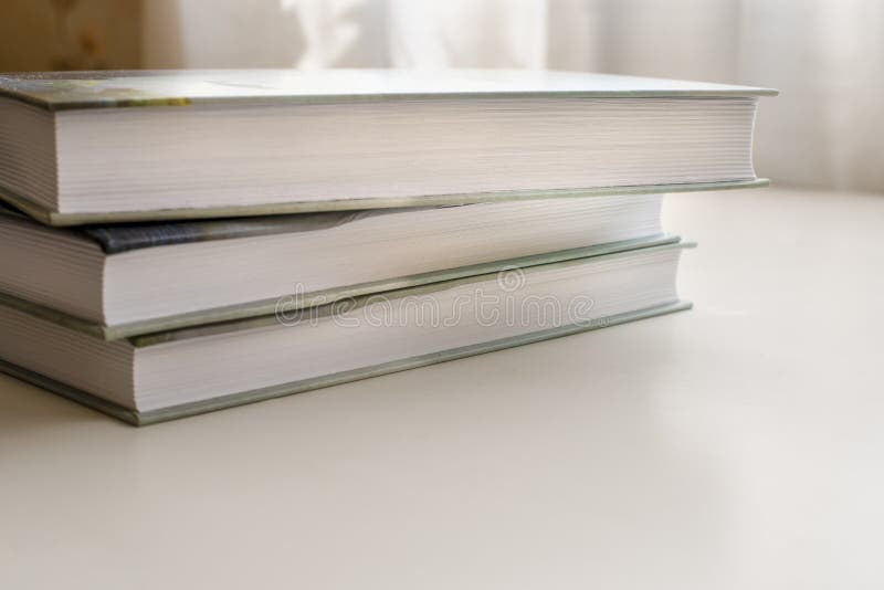 Three Books Lie on a White Table Stock Photo - Image of table, books ...