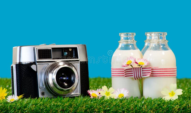 Three Bottles of Milk with a Camera in the Grass Stock Photo - Image of ...