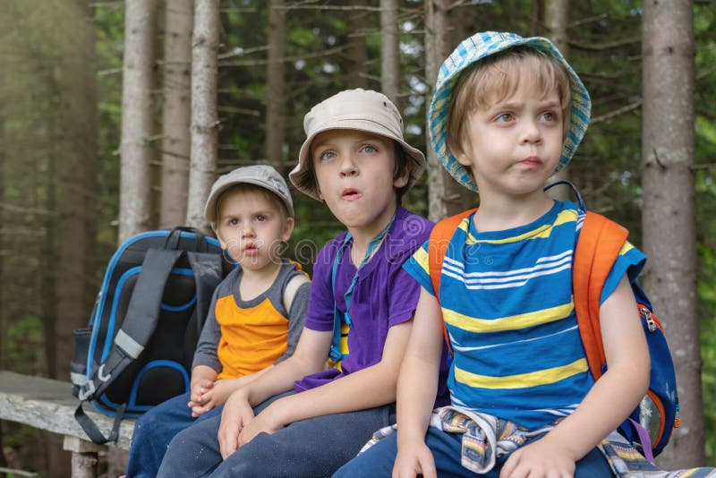 Three Boys are Sitting on a Bench. they Rest during the Journey Stock ...