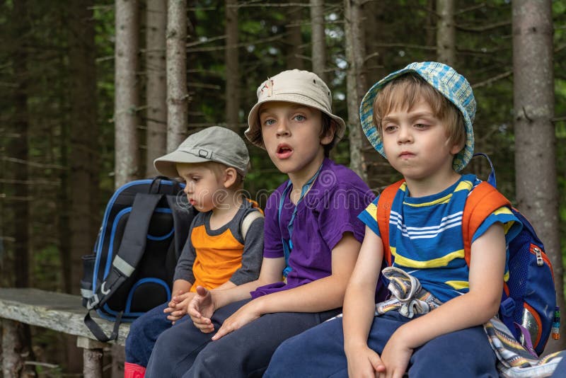 Three Boys are Sitting on a Bench. during the Trip, they Rest Stock ...