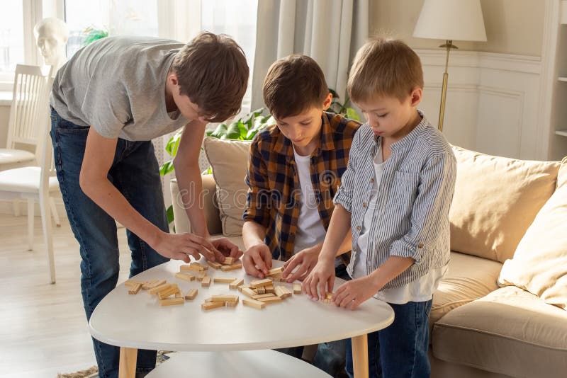 Three Boys, in Home Enthusiastically Play a Board Game Made of Wooden ...