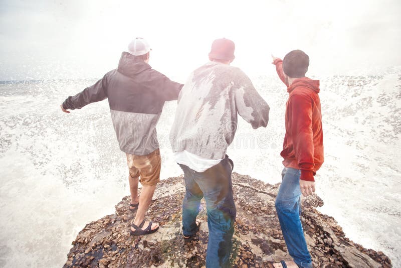 Three Brave Men Standing on a Cliff Stock Image - Image of rock, beach ...