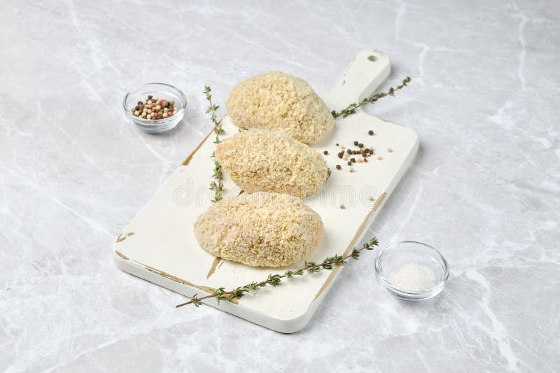Three Breaded Meat Cutlets on a Wooden Cutting Board Surrounded by ...