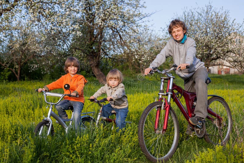 Three brothers ride bikes stock image. Image of nature - 109146363