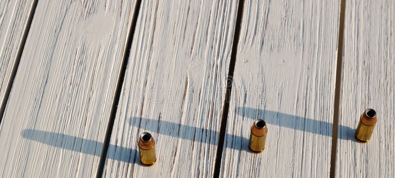 Three Bullets on a Wooden Background Stock Image - Image of ammunition ...