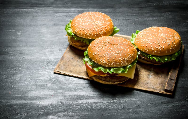 Three Burgers on a Wooden Board. Stock Image - Image of delicious ...