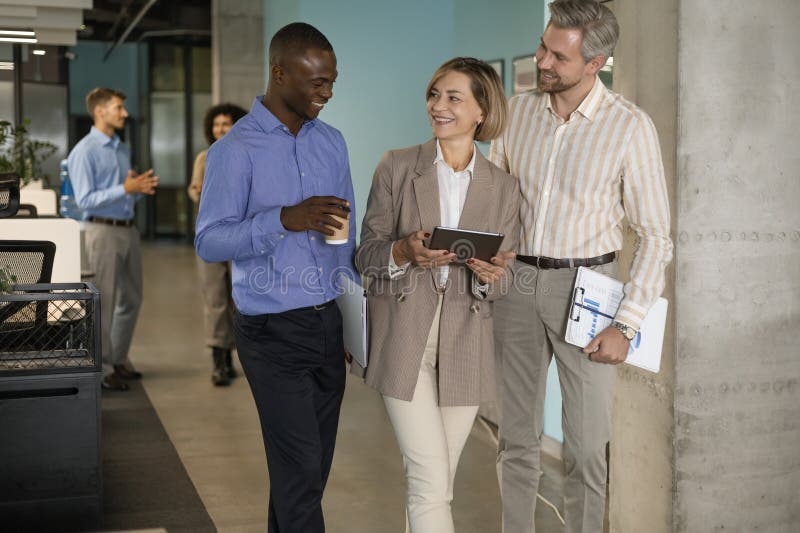 Three Business People Discussing Work Together Using a Tablet in a ...
