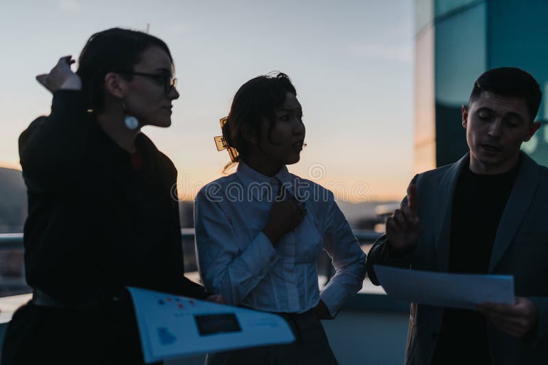 Three Business People are Engaged in a Discussion on a Rooftop at ...