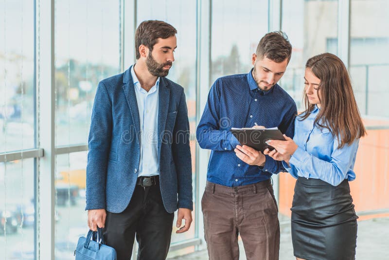 Three Business People in the Office. the Secretary Keeps a Folder with ...