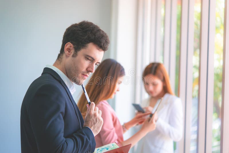 Three Business People Writing Idea on a Book in Team Meeting Stock ...