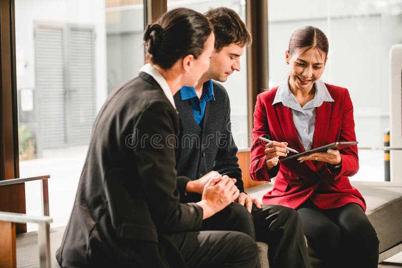 Three Business Professionals Meet in Modern Office Lobby, Discussing Documents on Tablet. Scene ...
