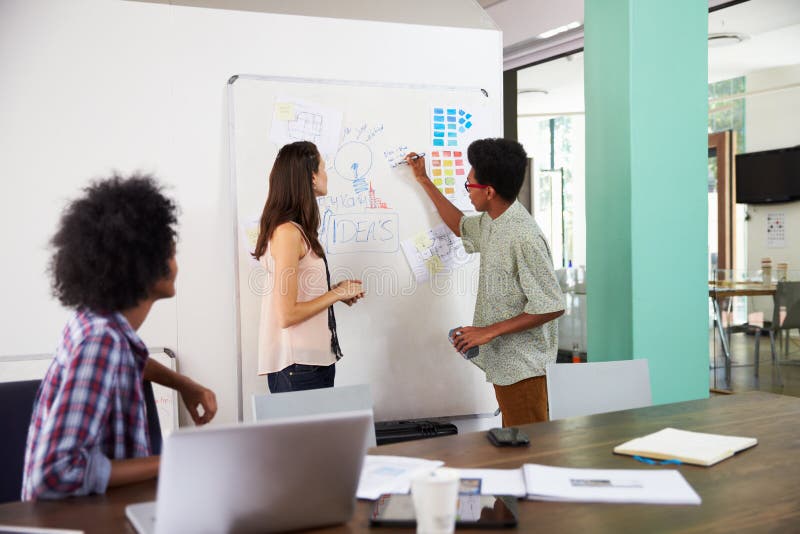 Three Businesspeople Having Creative Meeting in Office Stock Photo ...