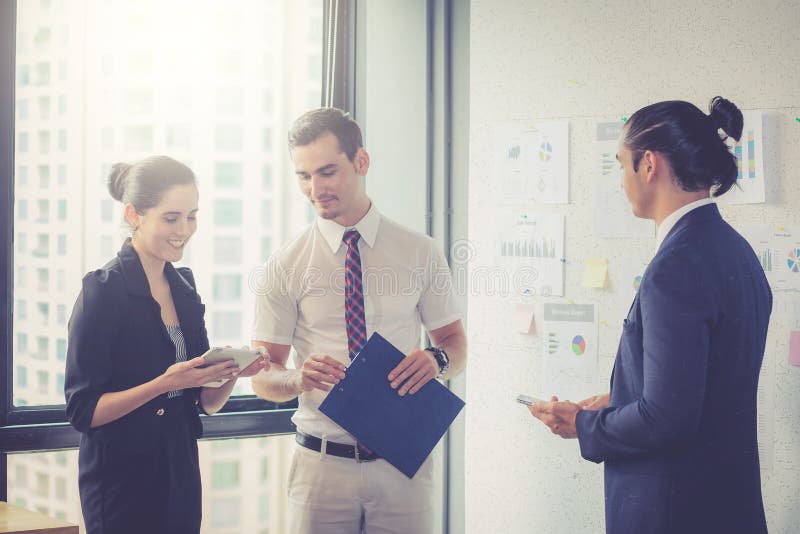 Three Businesspeople Standing in Modern Office Talking in Meeting Room ...