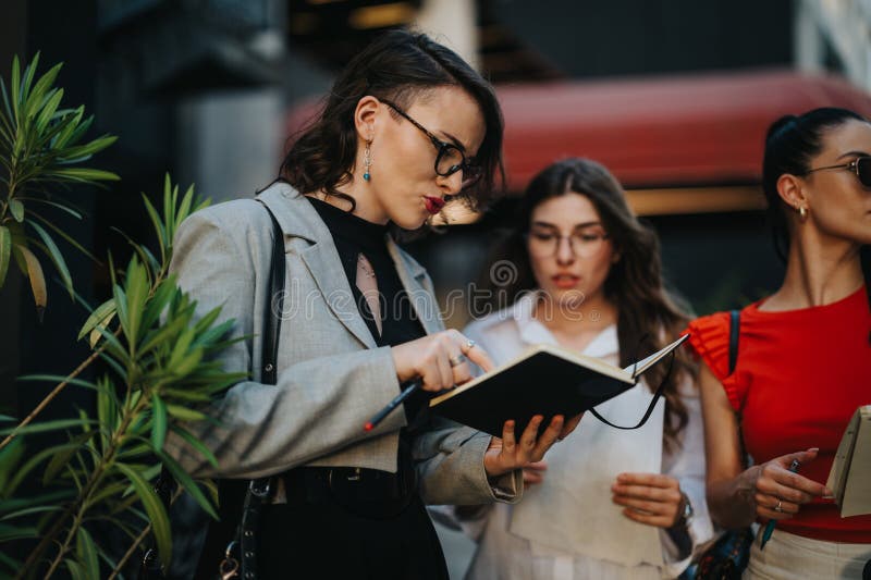 Businesswomen Discussing Work Outdoors, Taking Notes and Collaborating ...