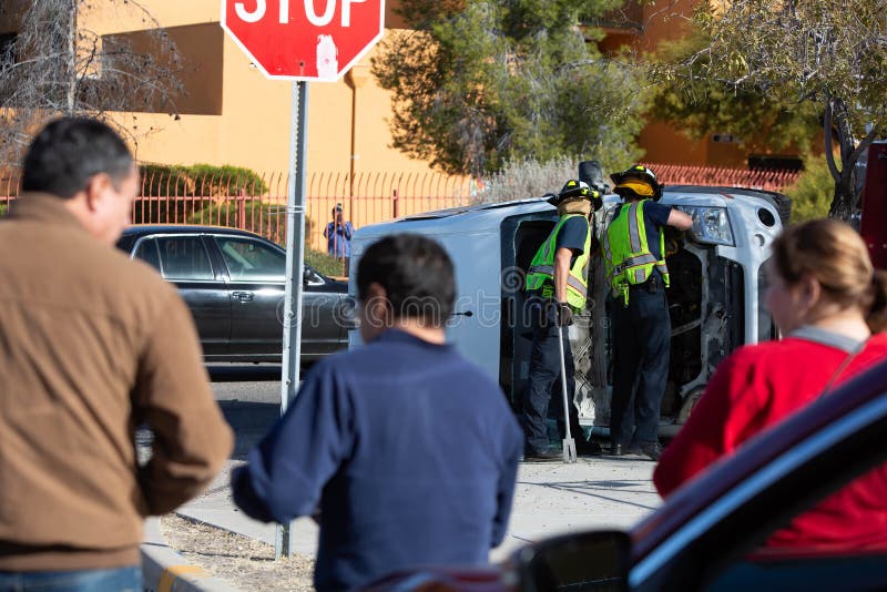 Three Bystanders Watch Emergency Responders Clearing a Crashed Minivan ...