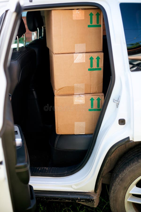 Three Cardboard Boxes with Green Sing this Way Up on the Back Seat of ...