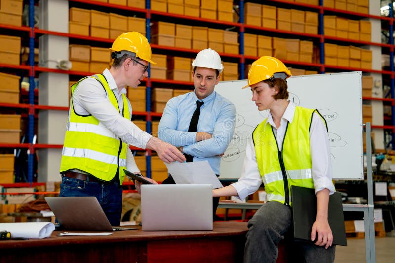 Three Caucasian Warehouse Workers Discuss about the Project Using Paper ...