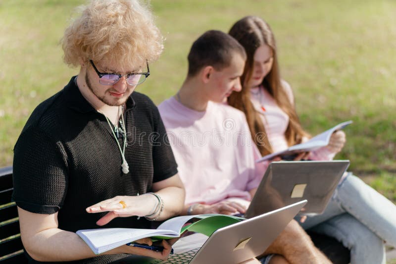 Three Cheerful Students Study and Work Together Outdoors on a Sunny Day ...