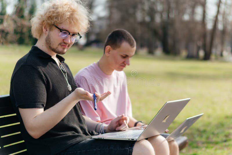 Three Cheerful Students Study and Work Together Outdoors on a Sunny Day ...