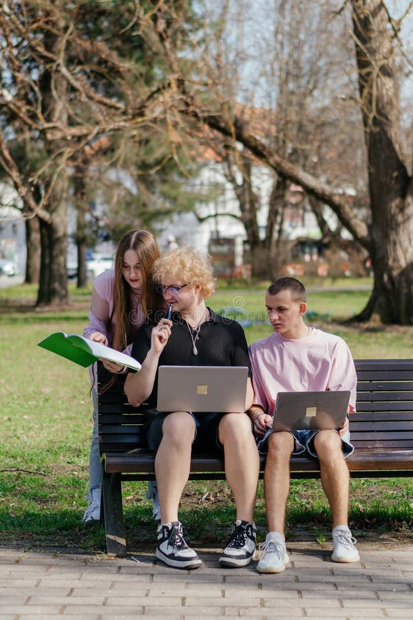 Three Cheerful Students Study and Work Together Outdoors on a Sunny Day ...