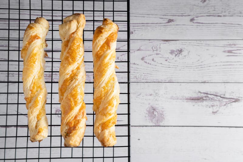 Three Cheese Sticks of Puff Pastry with Spices on a Baking Grate with ...