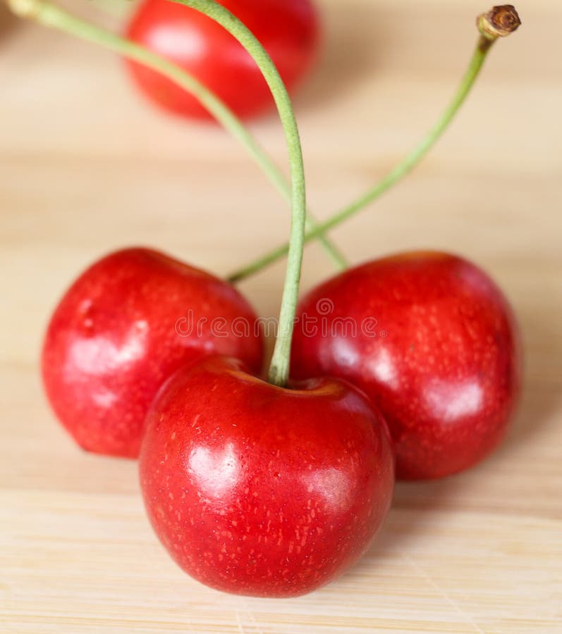 Three Cherries on Wooden Table Stock Image - Image of wooden, cherry ...