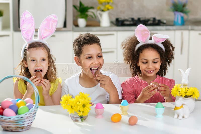 Three Children in Bright Clothes Eating Easter Eggs Stock Image - Image ...