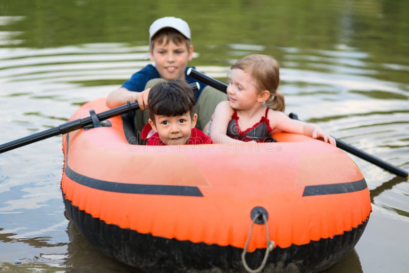 Three Children Float on a Rubber Boat with Oars, Stock Image - Image of ...