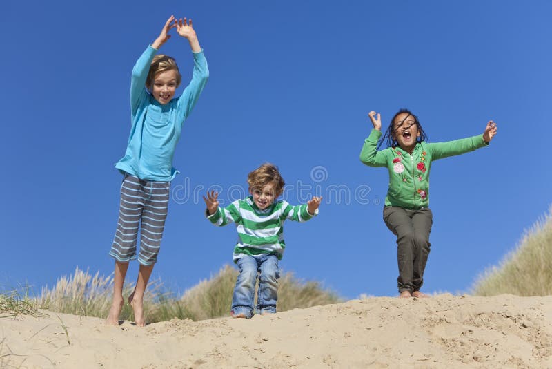Three Children Jumping Having Fun on Beach Stock Photo - Image of mixed ...