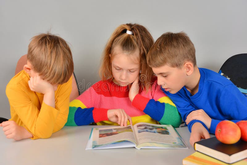 Three Children Read a Book and Do Their Homework Assigned at School ...