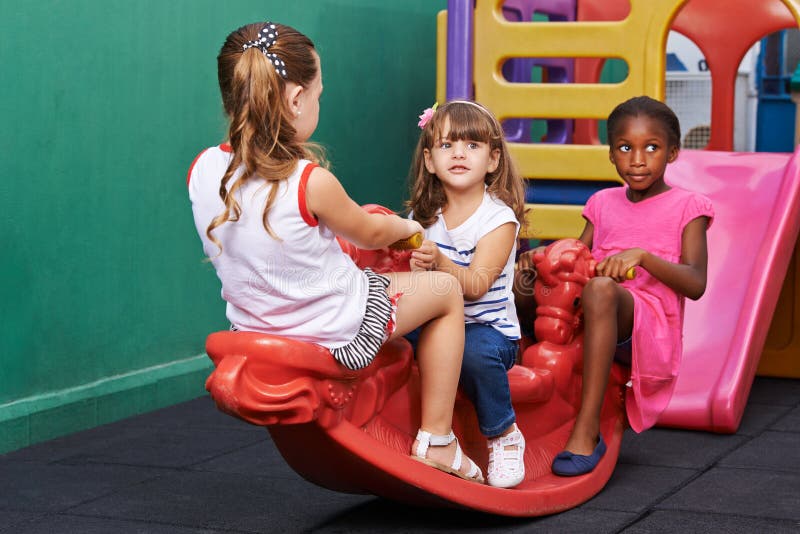 Three Children Rocking on Rocker Stock Photo - Image of interracial ...