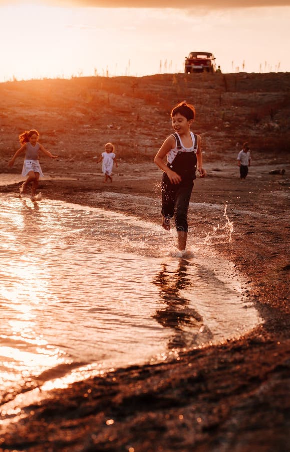 Three Children Running Along Beach Stock Image - Image of sand ...