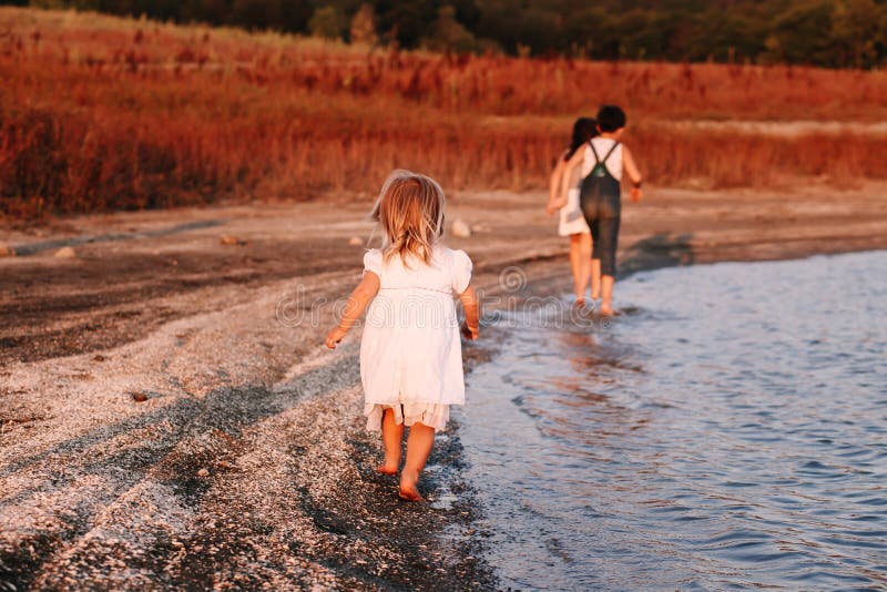 Three Children Running Along Beach Stock Photo - Image of caucasian ...