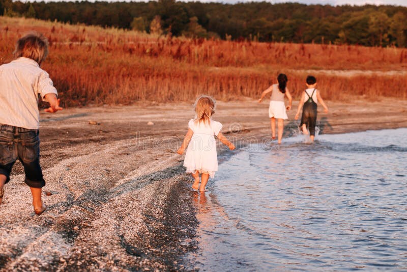 Three Children Running Along Beach Stock Image - Image of beach, friend ...