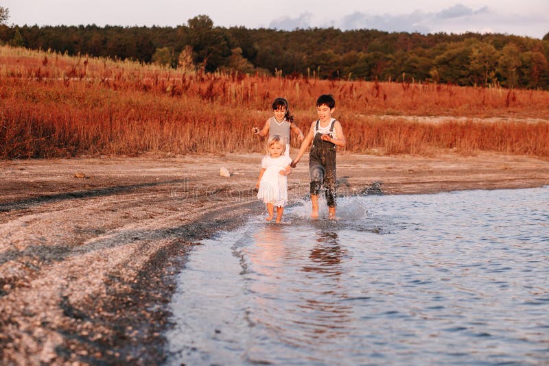 Three Children Running Along Beach Stock Photo - Image of caucasian ...