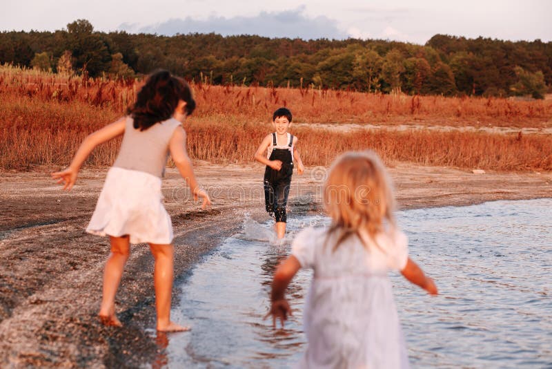Three Children Running Along Beach Stock Photo - Image of length ...