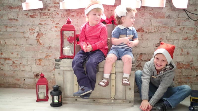 Three Children in Santa Caps Pose in Studio with Stock Video - Video of ...