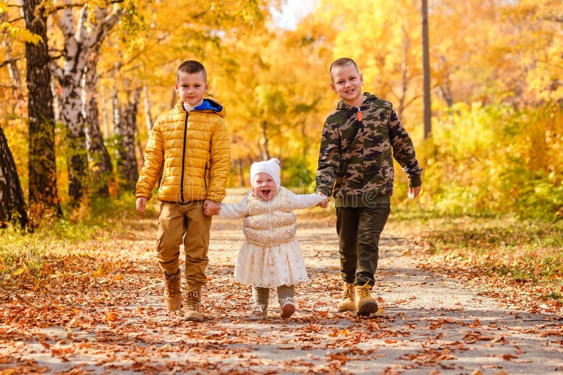 Three Children Walk Along the Path in the Autumn Park Stock Photo ...