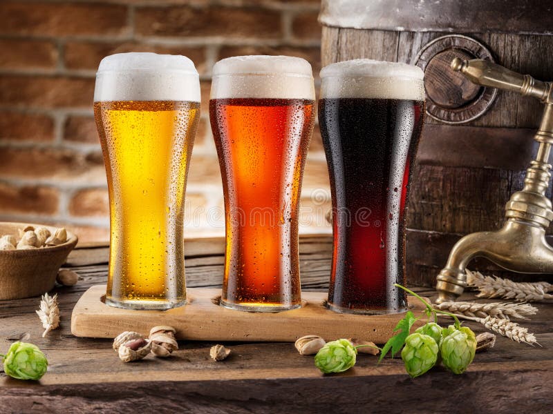 Three Chilled Glasses of Different Beer and Beer Barrel on Wooden Table ...
