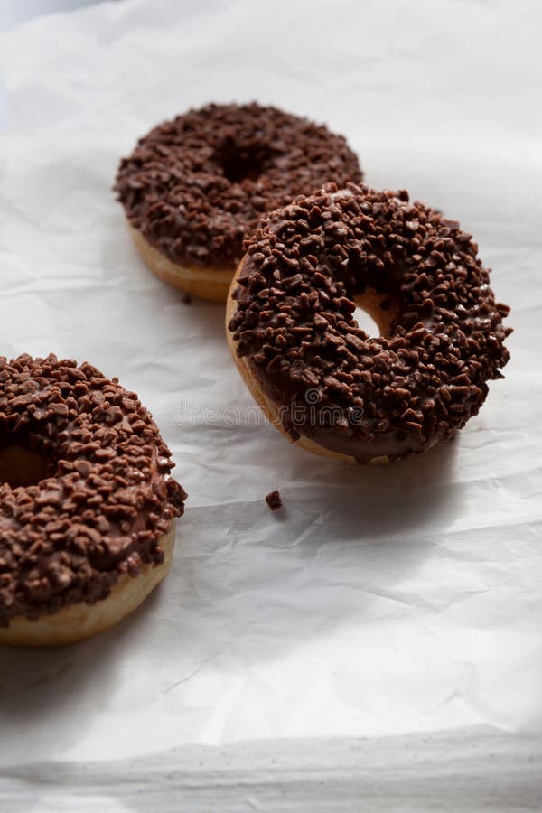 Three chocolate doughnuts stock photo. Image of fried - 52472514