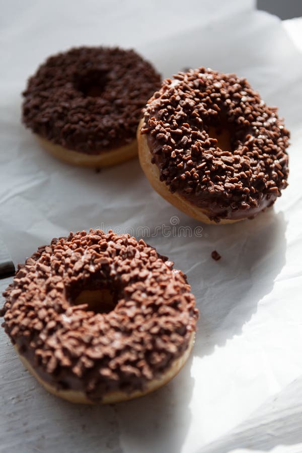 Three chocolate doughnuts stock image. Image of frosting - 52472545