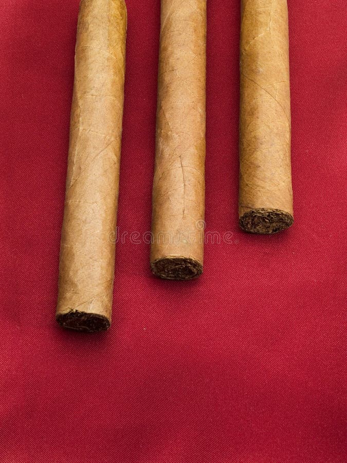 Three Cigars on red satin stock image. Image of culture - 49418407