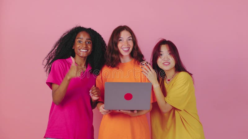 Three Close Friends Gather Around a Laptop, Joyfully Using it while ...