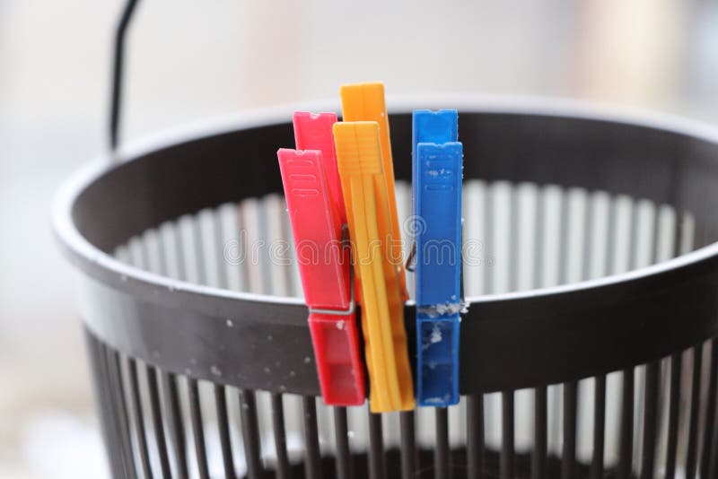 A Three Clothes Pegs Attached To a Small Bucket Stock Photo - Image of ...